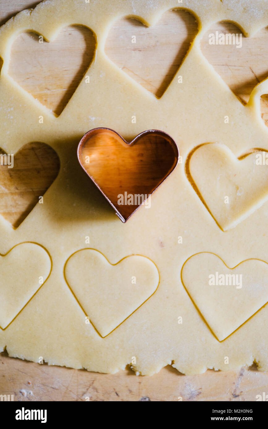 Baking Heart Shaped Cookies for valentine's day, over a wooden ...