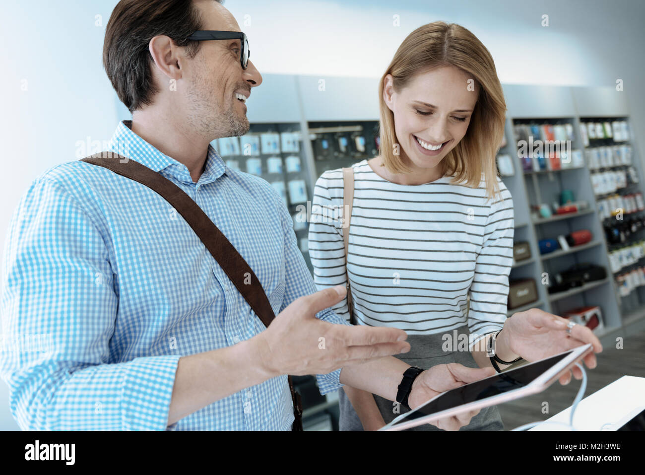 Delighted people visiting store with modern gadgets Stock Photo - Alamy