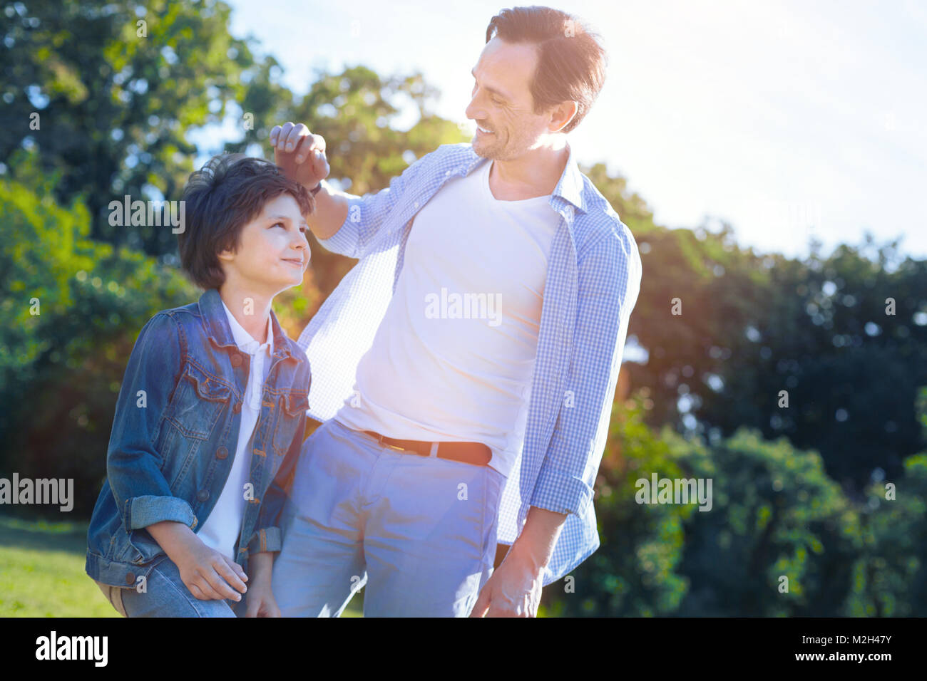 Cheerful father and son smiling to each other Stock Photo - Alamy