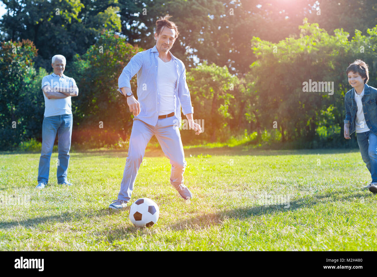 Supportive family playing soccer together Stock Photo - Alamy