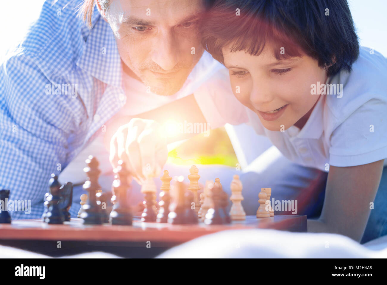 Close up of father and son playing chess Stock Photo - Alamy