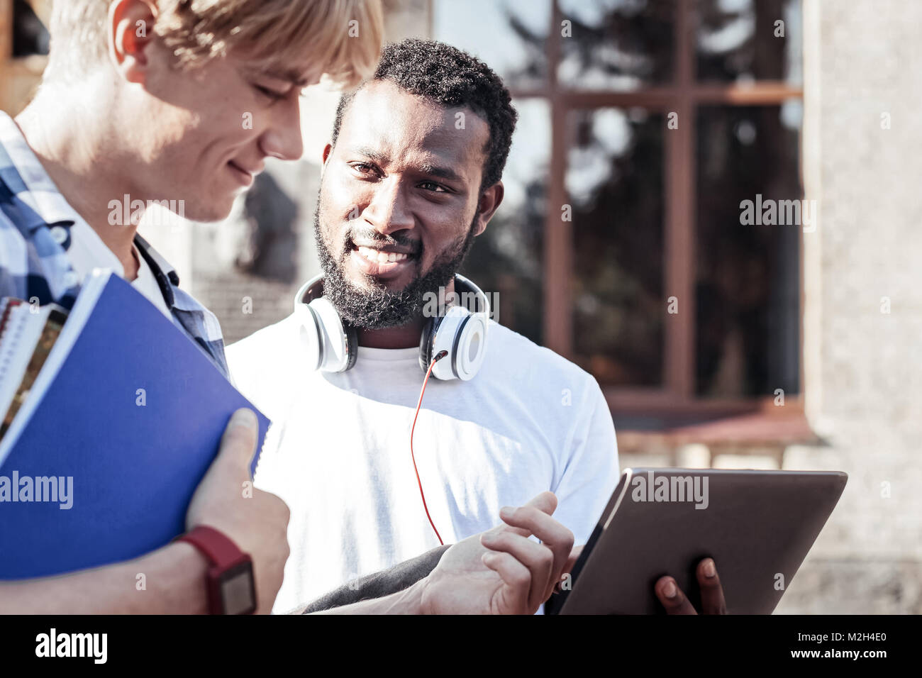 Delighted nice man looking at his friend Stock Photo - Alamy
