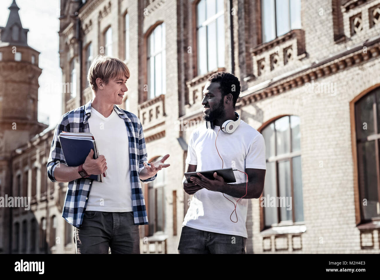 Nice male students talking to each other Stock Photo - Alamy