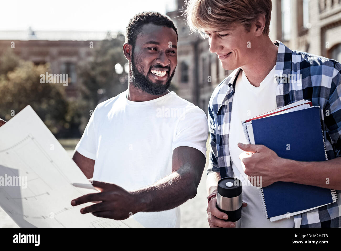 Delighted positive student holding a blueprint Stock Photo - Alamy