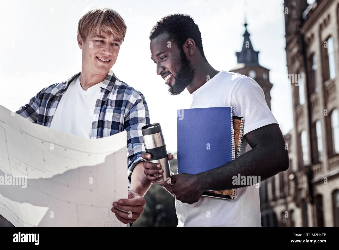 Smart joyful student looking at the drawing Stock Photo - Alamy