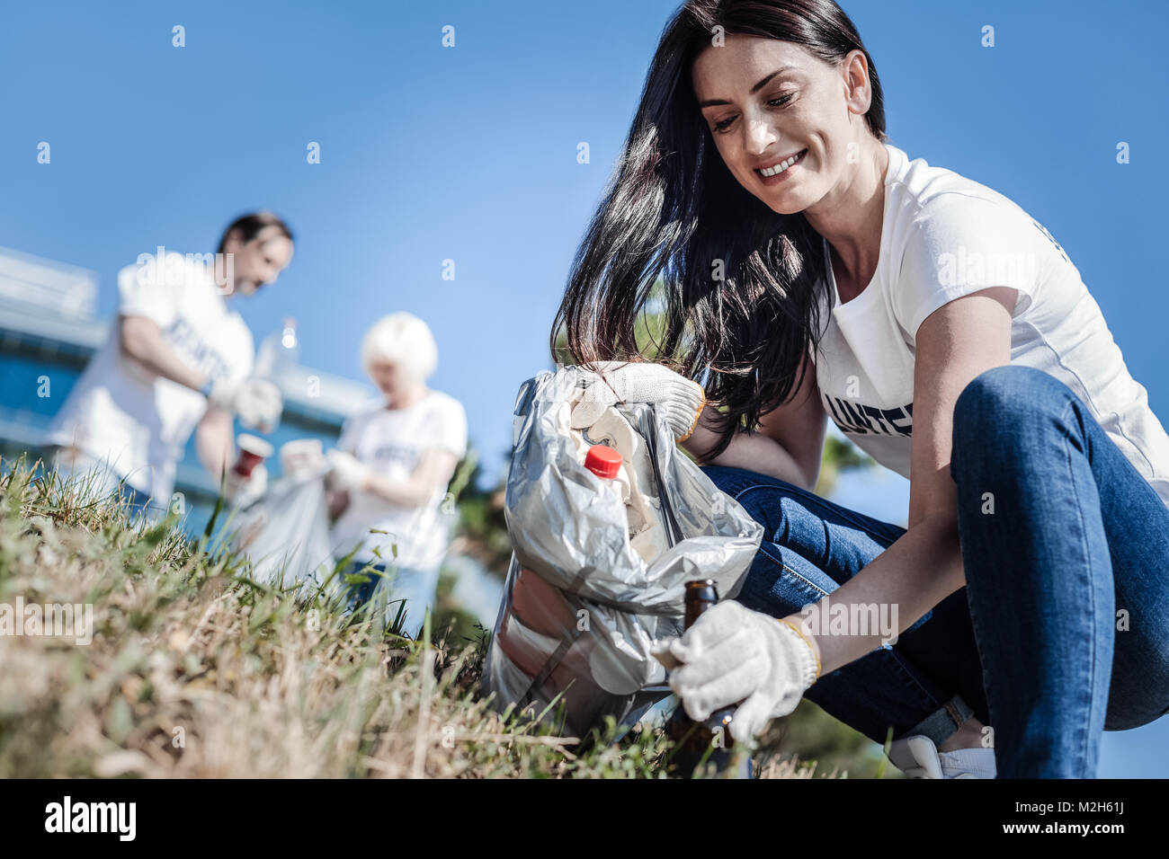Joyful nice woman collecting glass bottles Stock Photo - Alamy