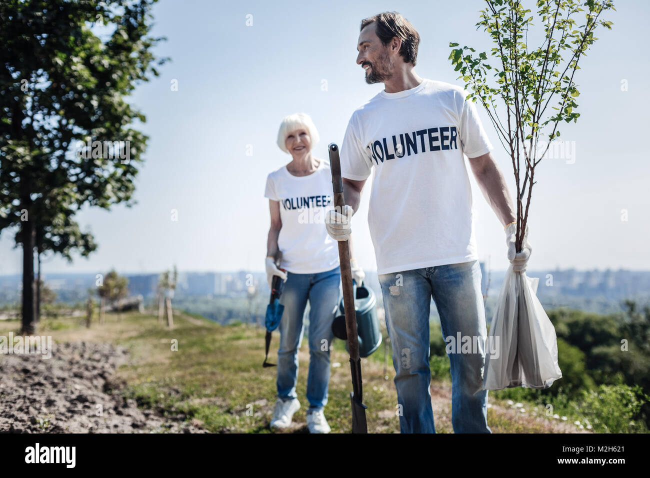 Joyful nice man holding a tree Stock Photo - Alamy
