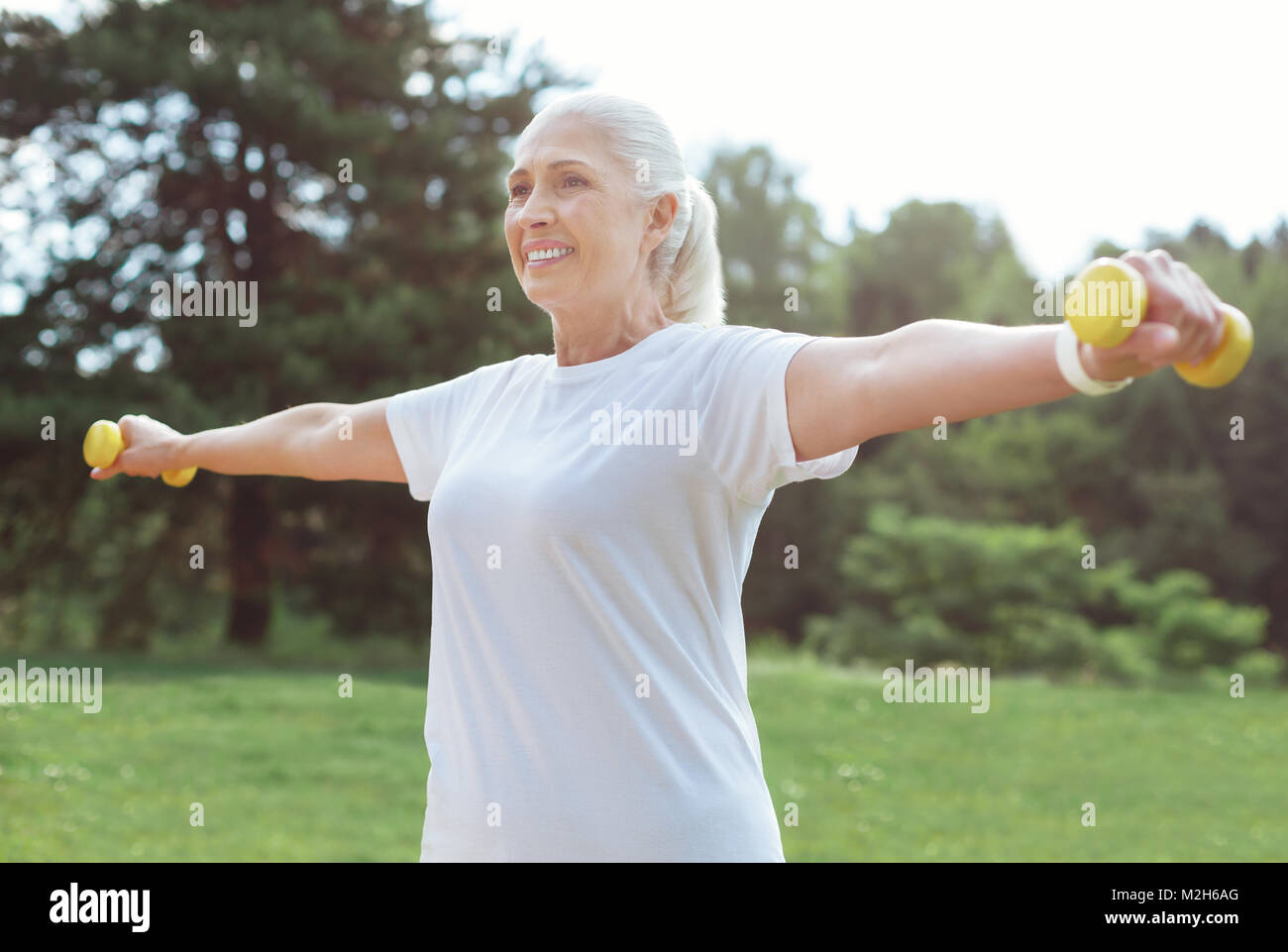Nice active woman exercising with dumbbells Stock Photo - Alamy
