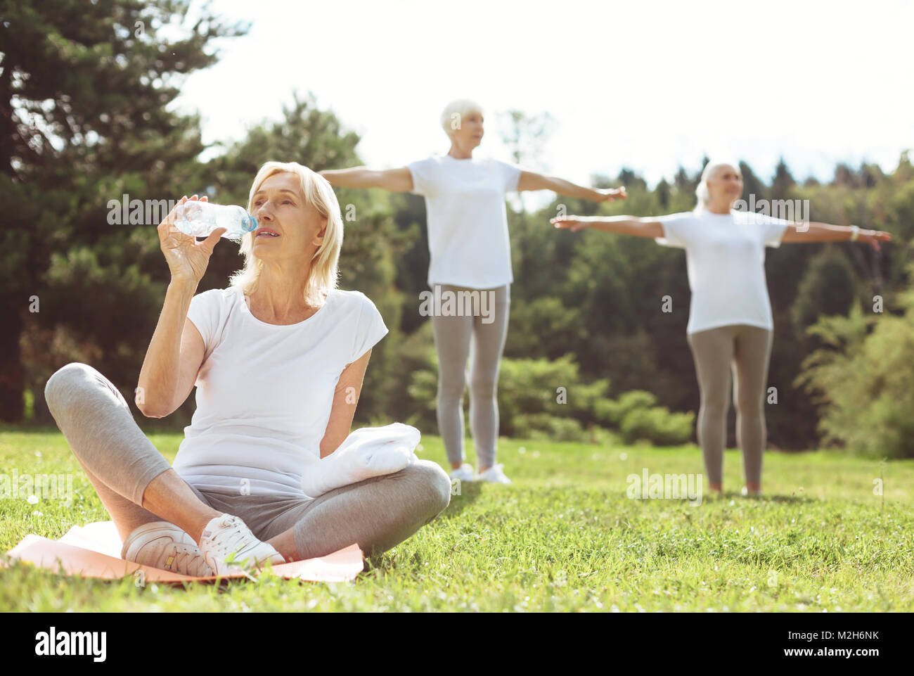 Positive delighted woman drinking water Stock Photo - Alamy