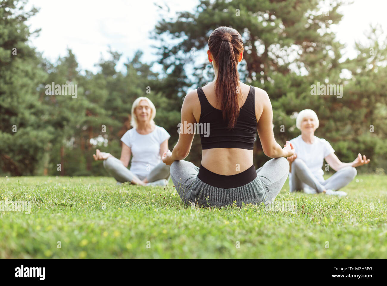 Nice young woman sitting opposite her group Stock Photo - Alamy