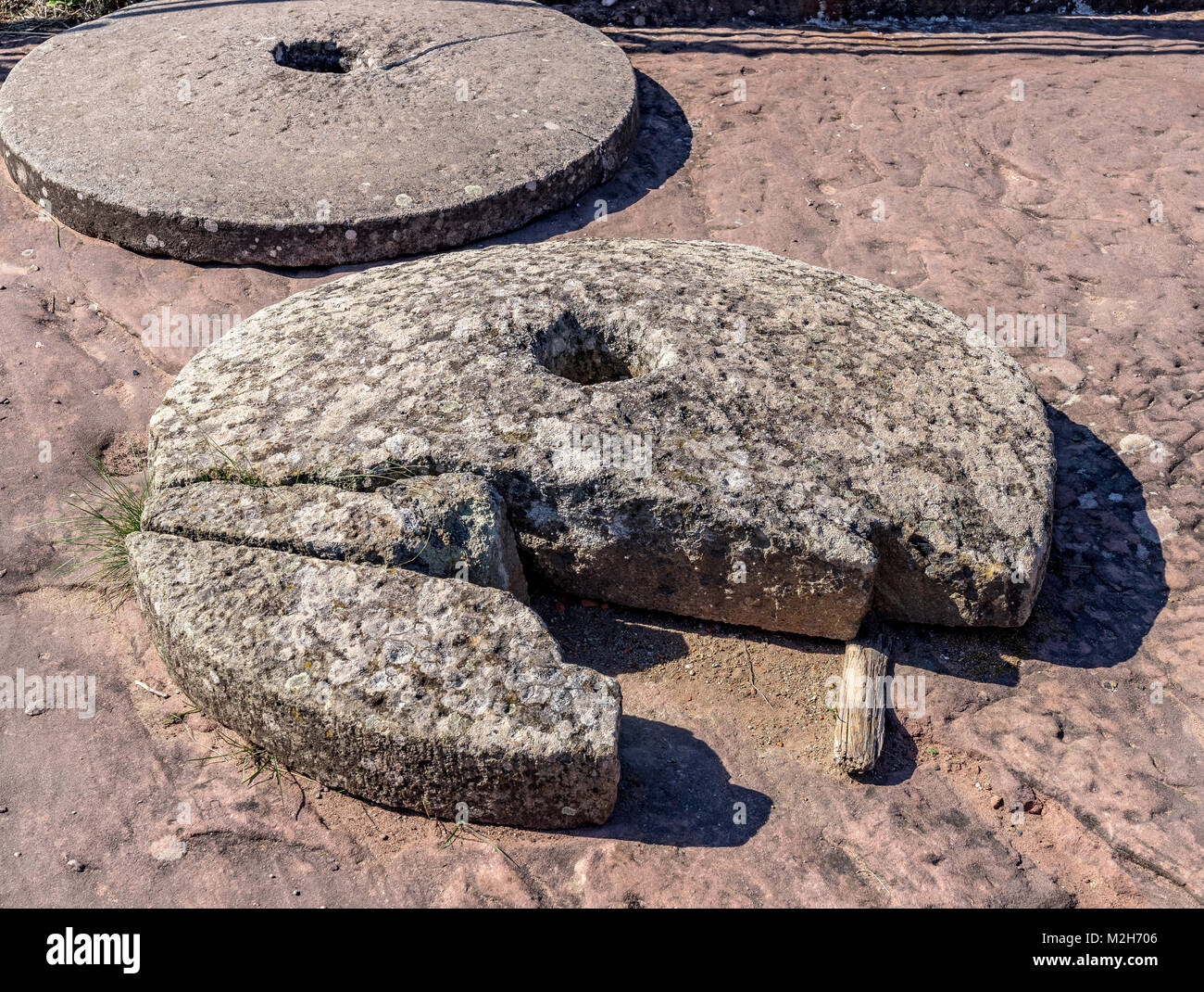 Broken medieval millstones lying on the ground in the sunlight Stock ...