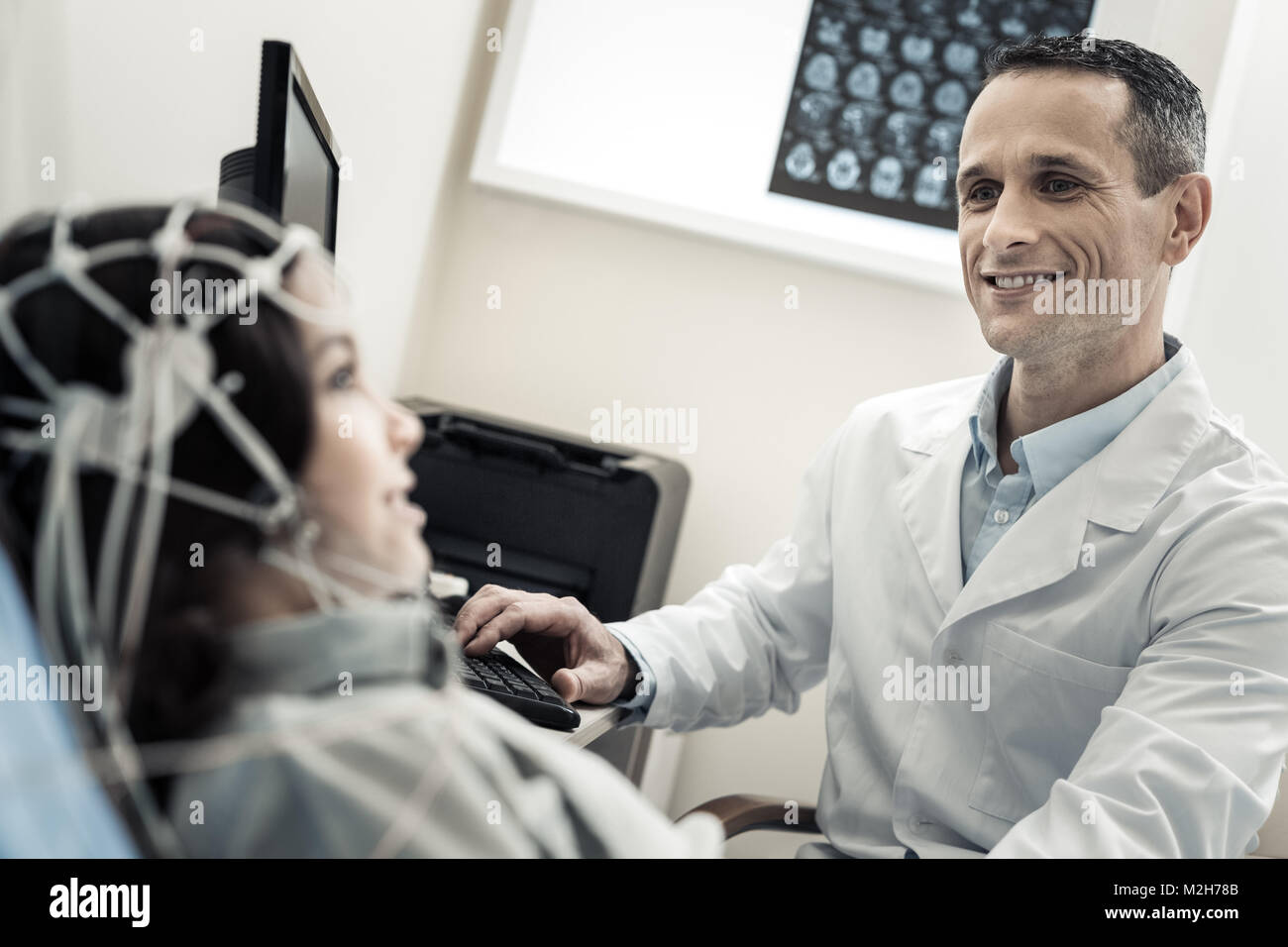 Happy cheerful doctor looking at his patient Stock Photo - Alamy