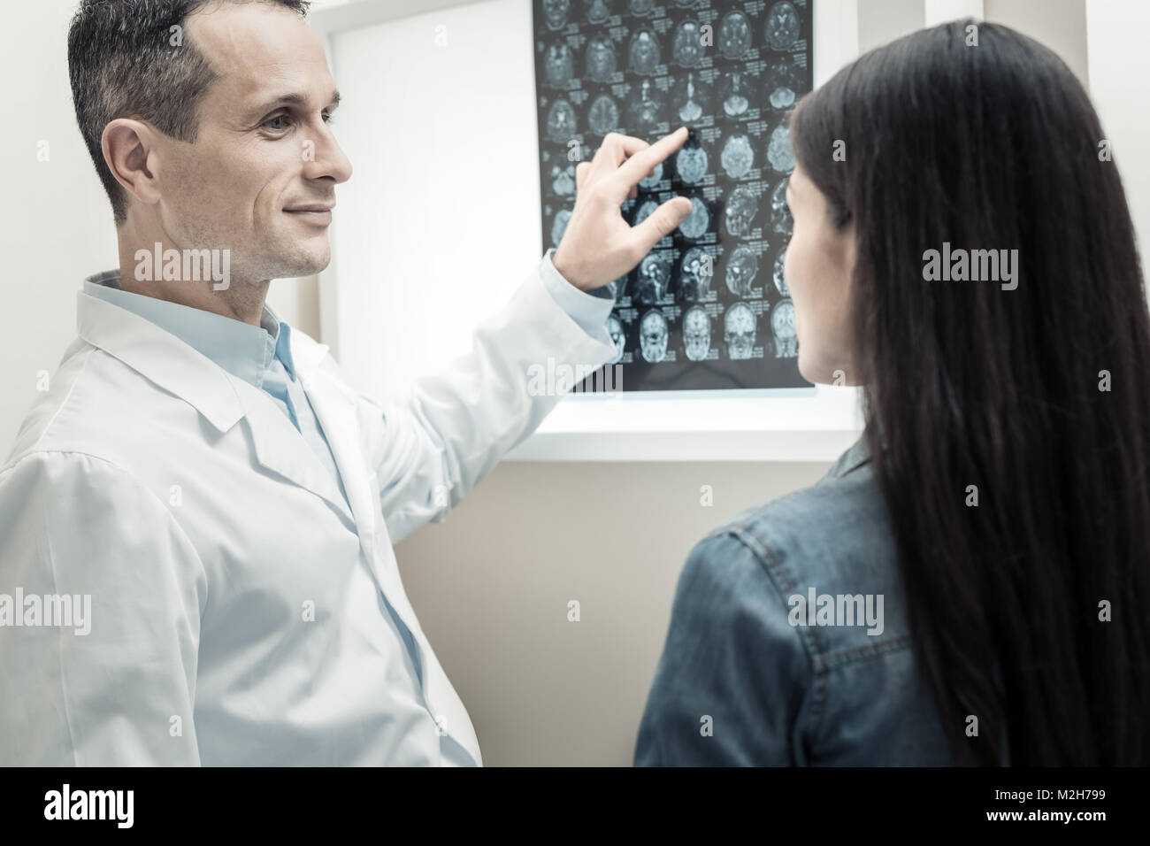 Cheerful positive doctor looking at his patient Stock Photo - Alamy