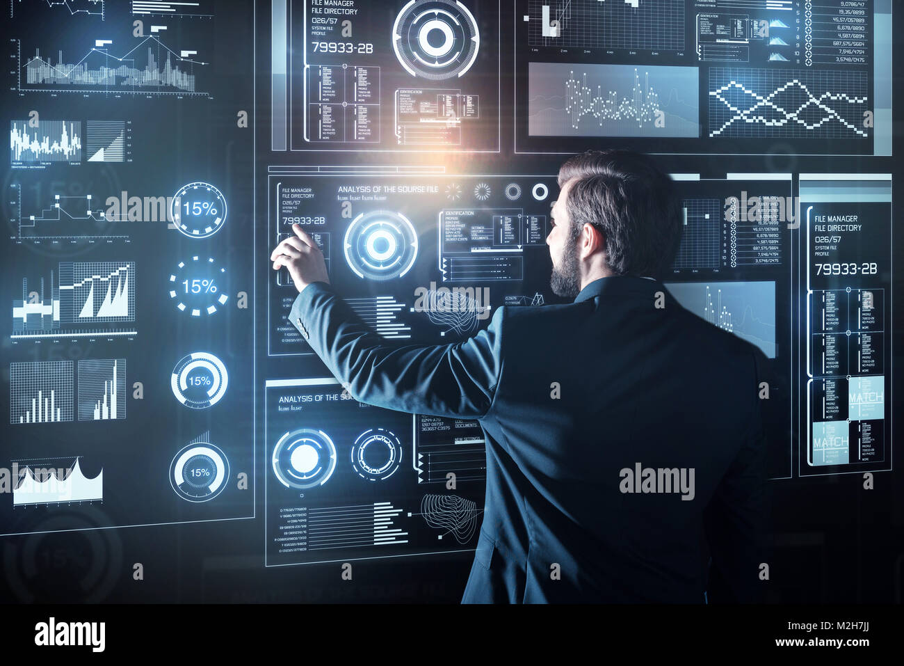 Elegant programmer standing in front of a futuristic device and ...