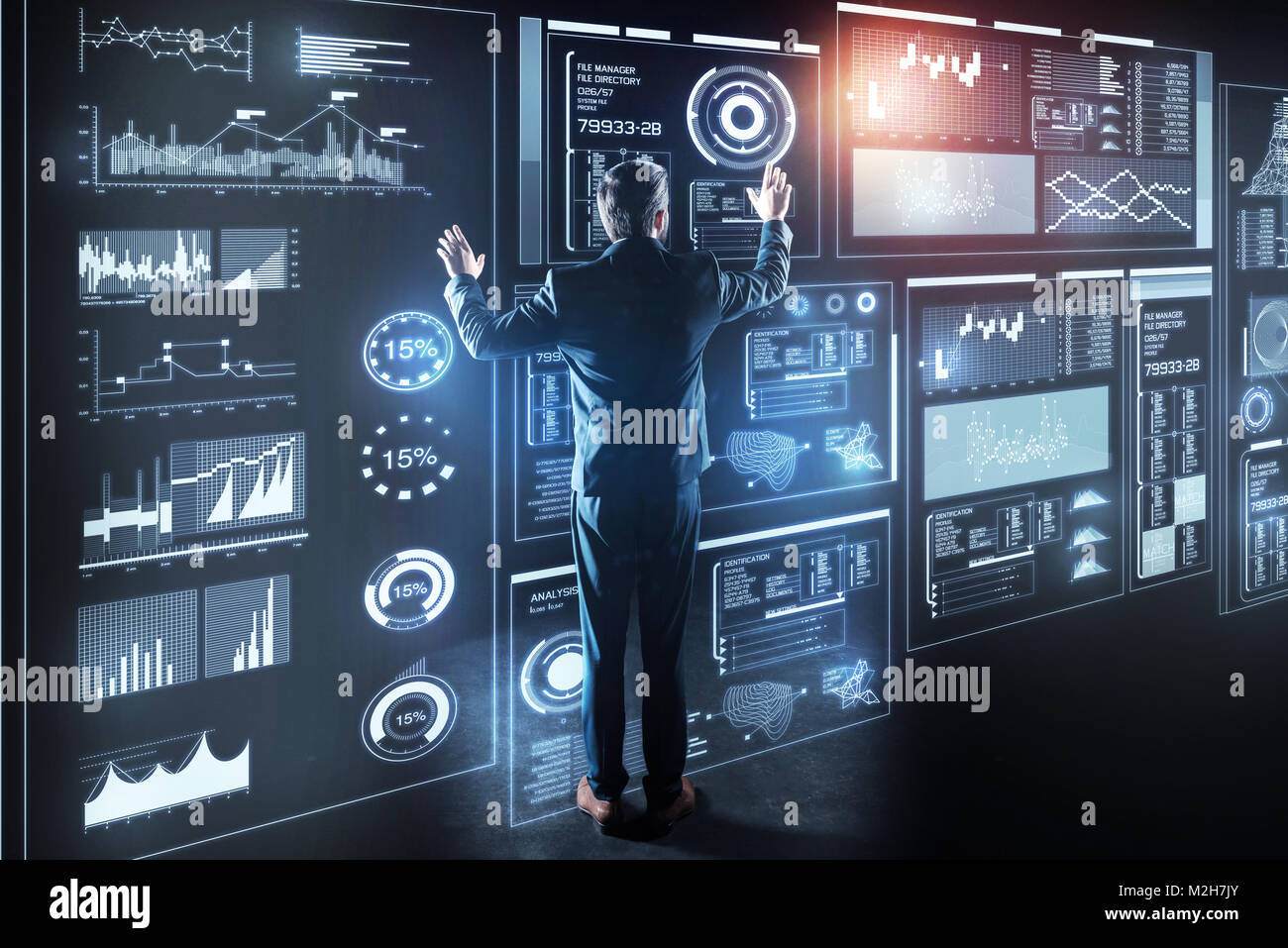 Elegant programmer standing in front of a giant transparent device and ...
