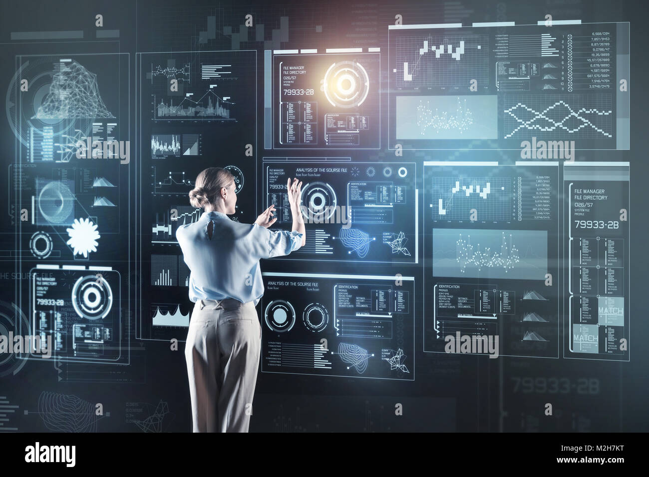 Busy programmer standing in front of a transparent screen and looking ...