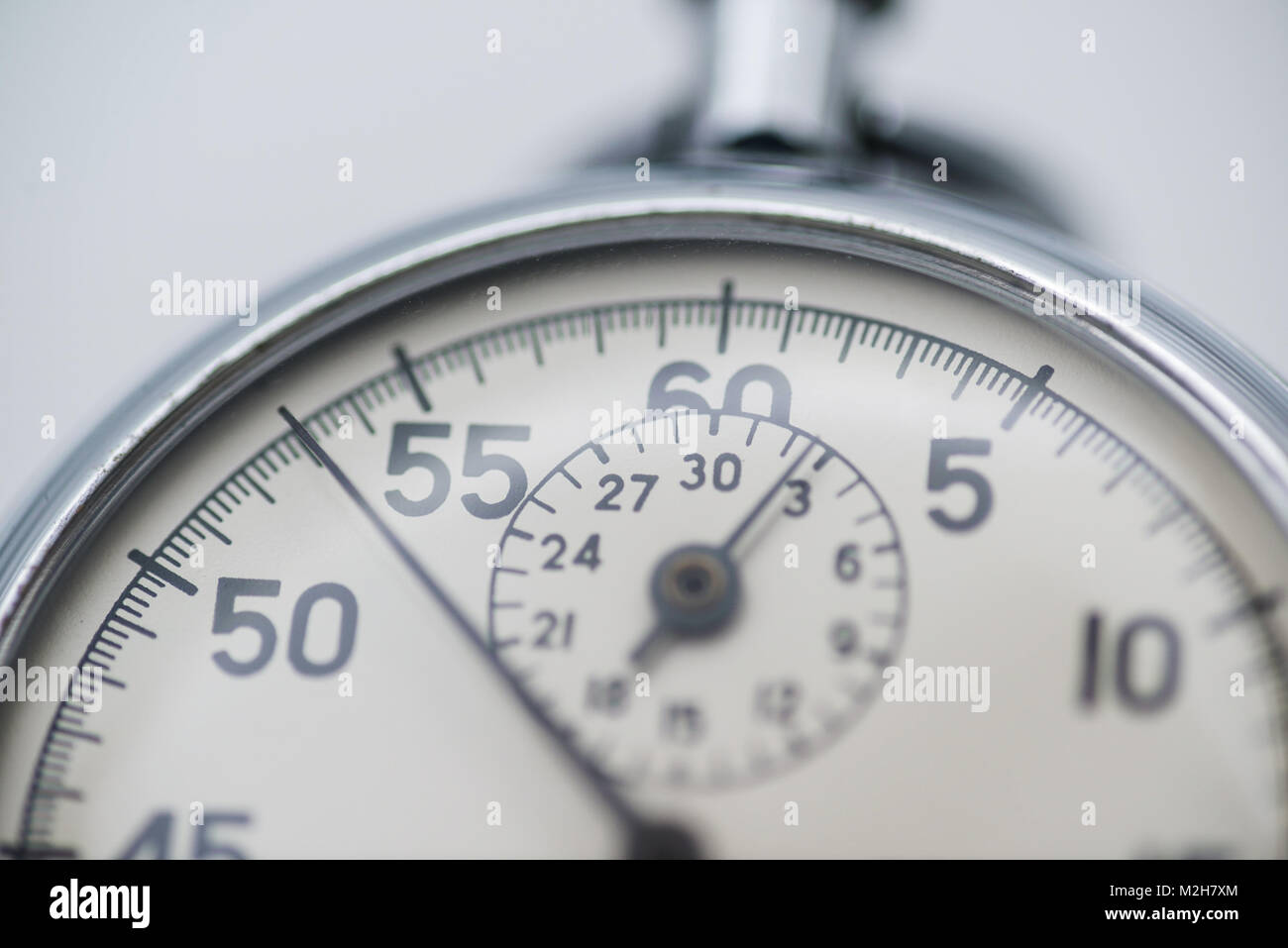 Close-up photograph of silver stopwatch. High key lighting on white ...