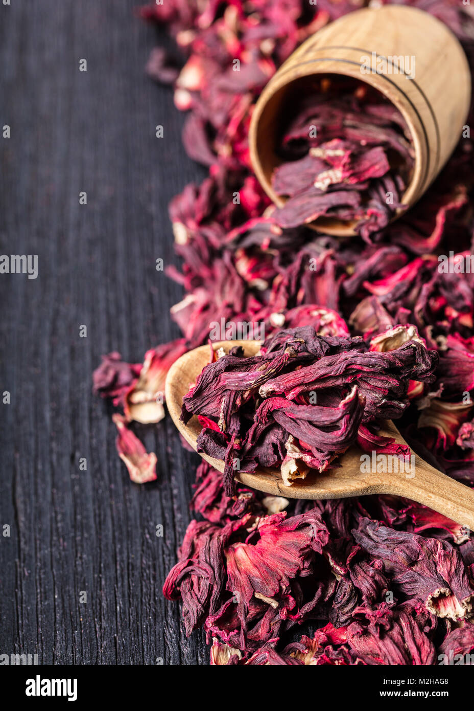 dry karkade tea on a wooden black background Stock Photo - Alamy