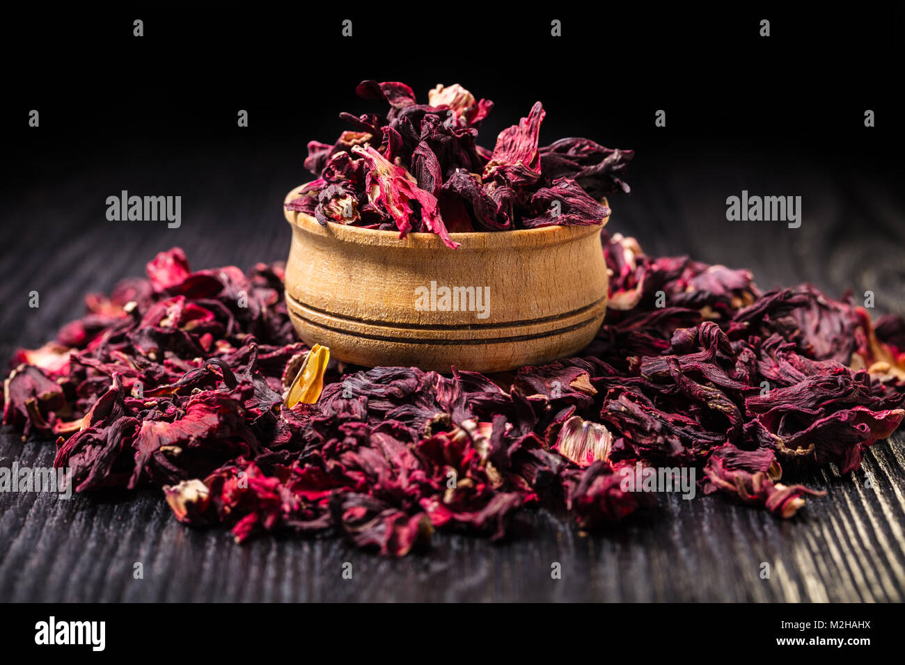 dry karkade tea on a wooden black background Stock Photo - Alamy
