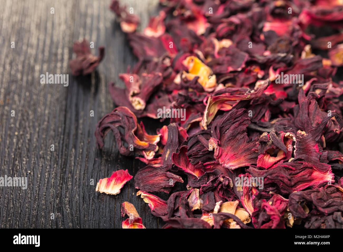 dry karkade tea on a wooden black background Stock Photo - Alamy