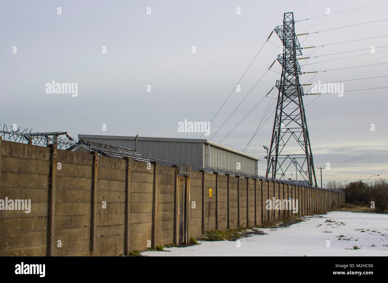 A tall steel electricity pylon on a large substation supply point in ...