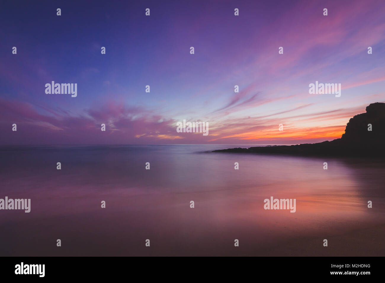 Stunning long-exposure of a sandy beach, silky smooth water, and ...
