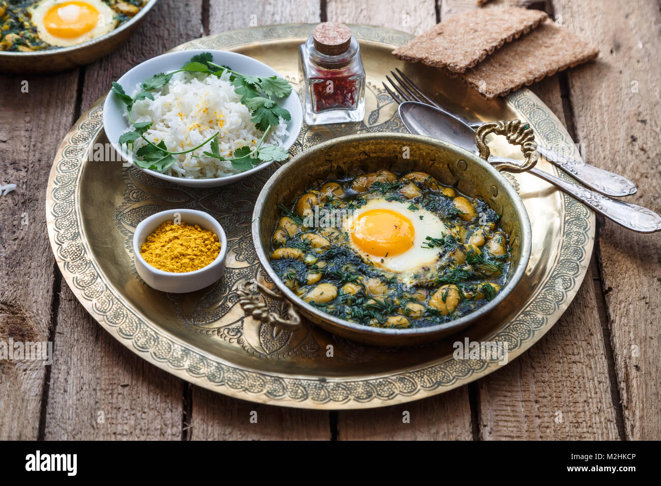 Persian breakfast with eggs, bean and dill in copper pan top view Stock ...