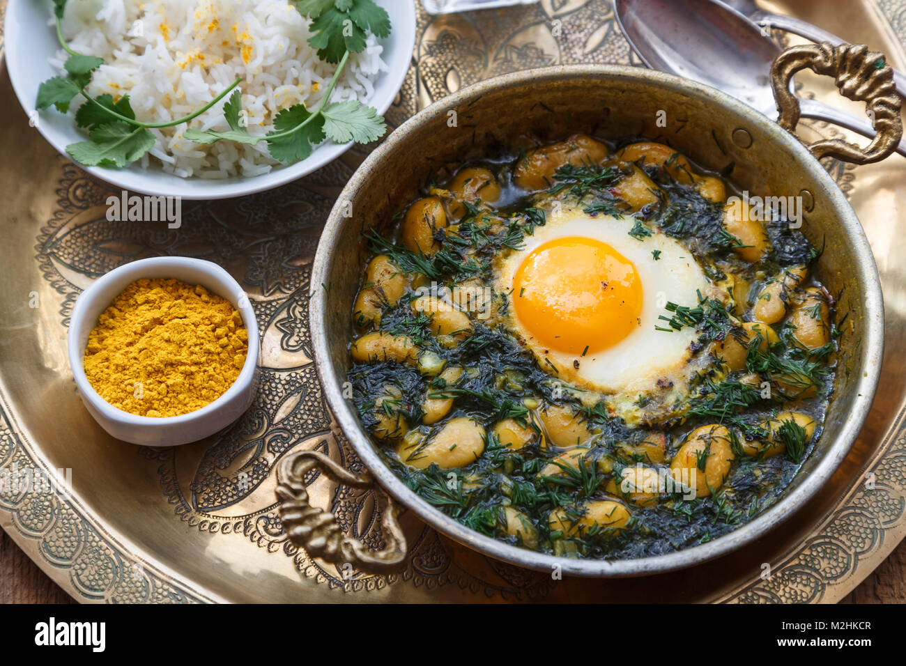 Persian breakfast with eggs, bean and dill in copper pan top view Stock ...