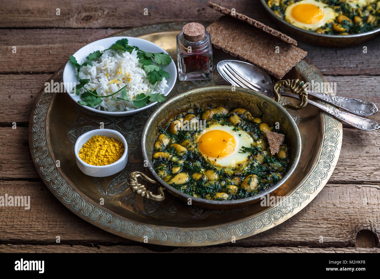 Iranian breakfast made with eggs, bean and dill. served with bread and ...