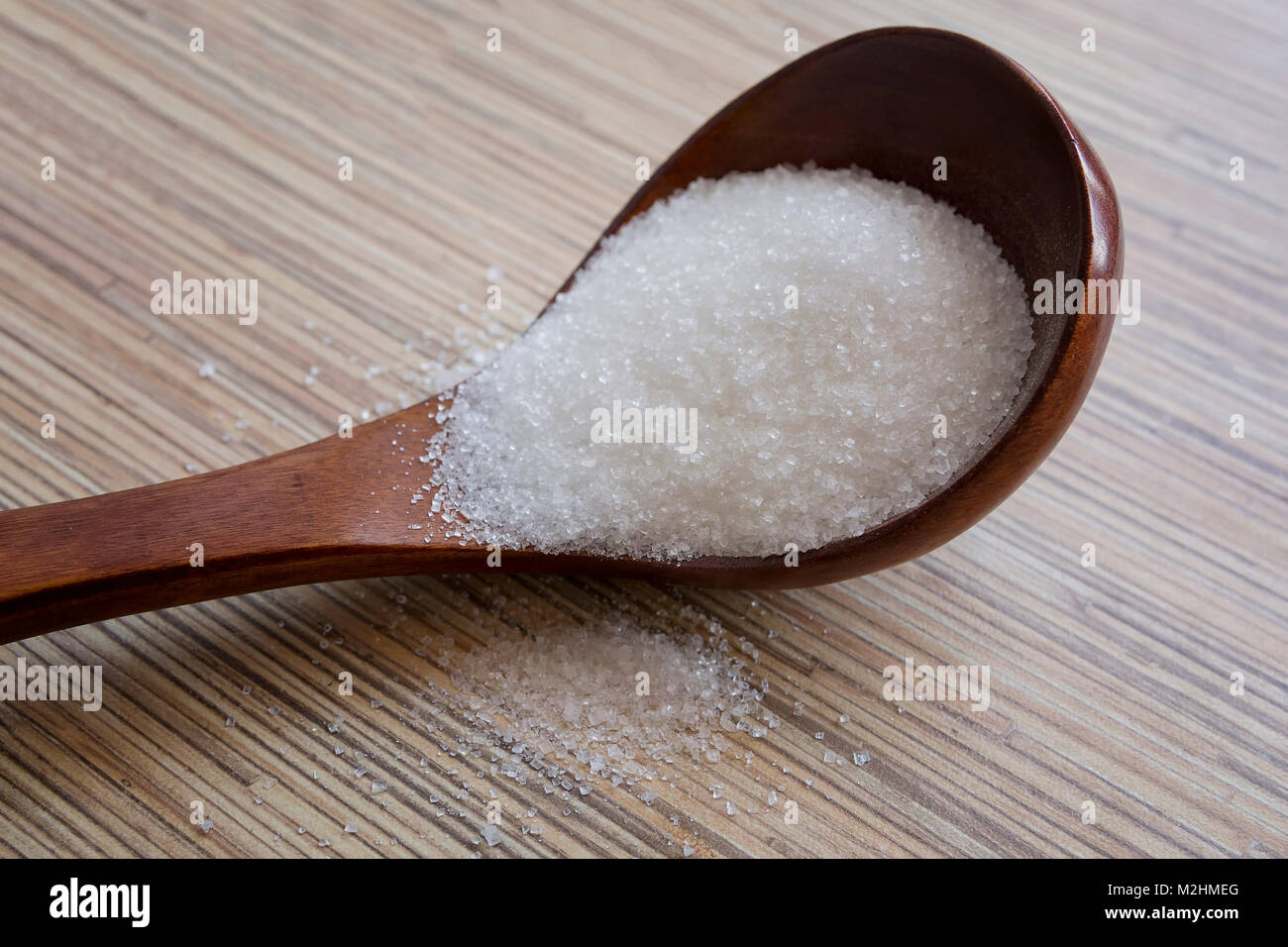 Wooden spoon with white sugar on wooden background Stock Photo - Alamy
