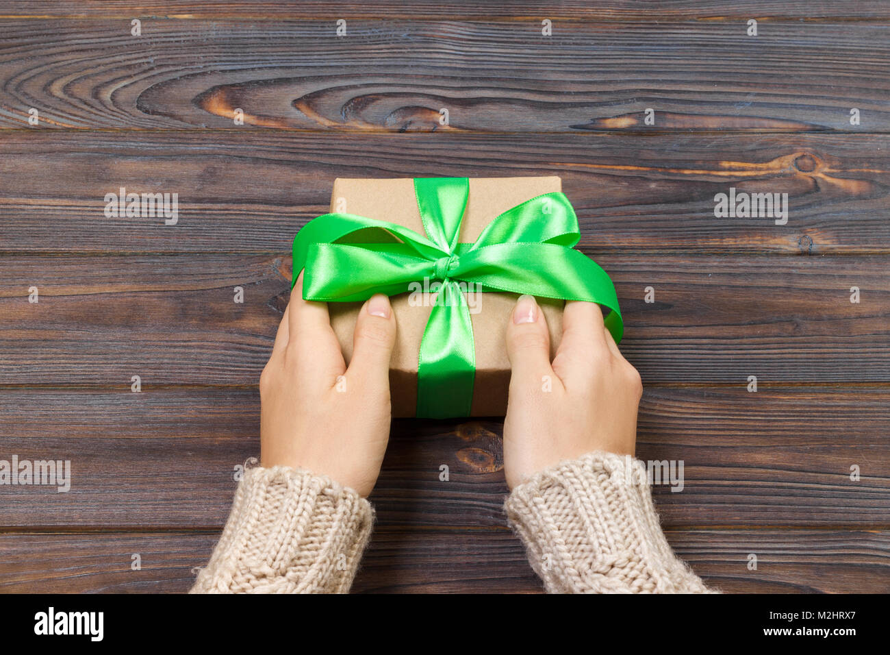 Woman's hands give wrapped valentine holiday handmade present in craft ...