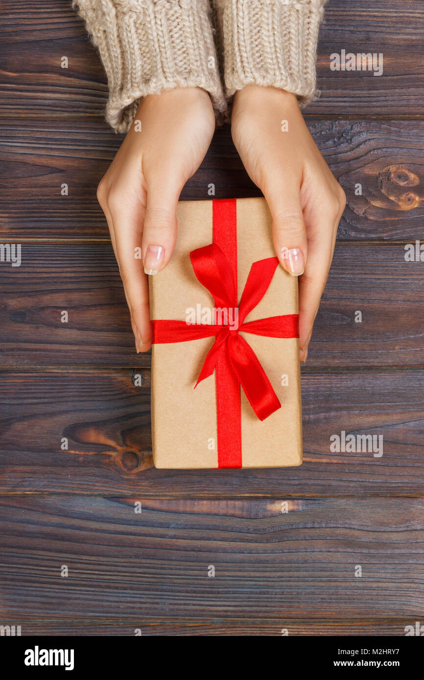 Woman's hands give wrapped valentine holiday handmade present in craft ...