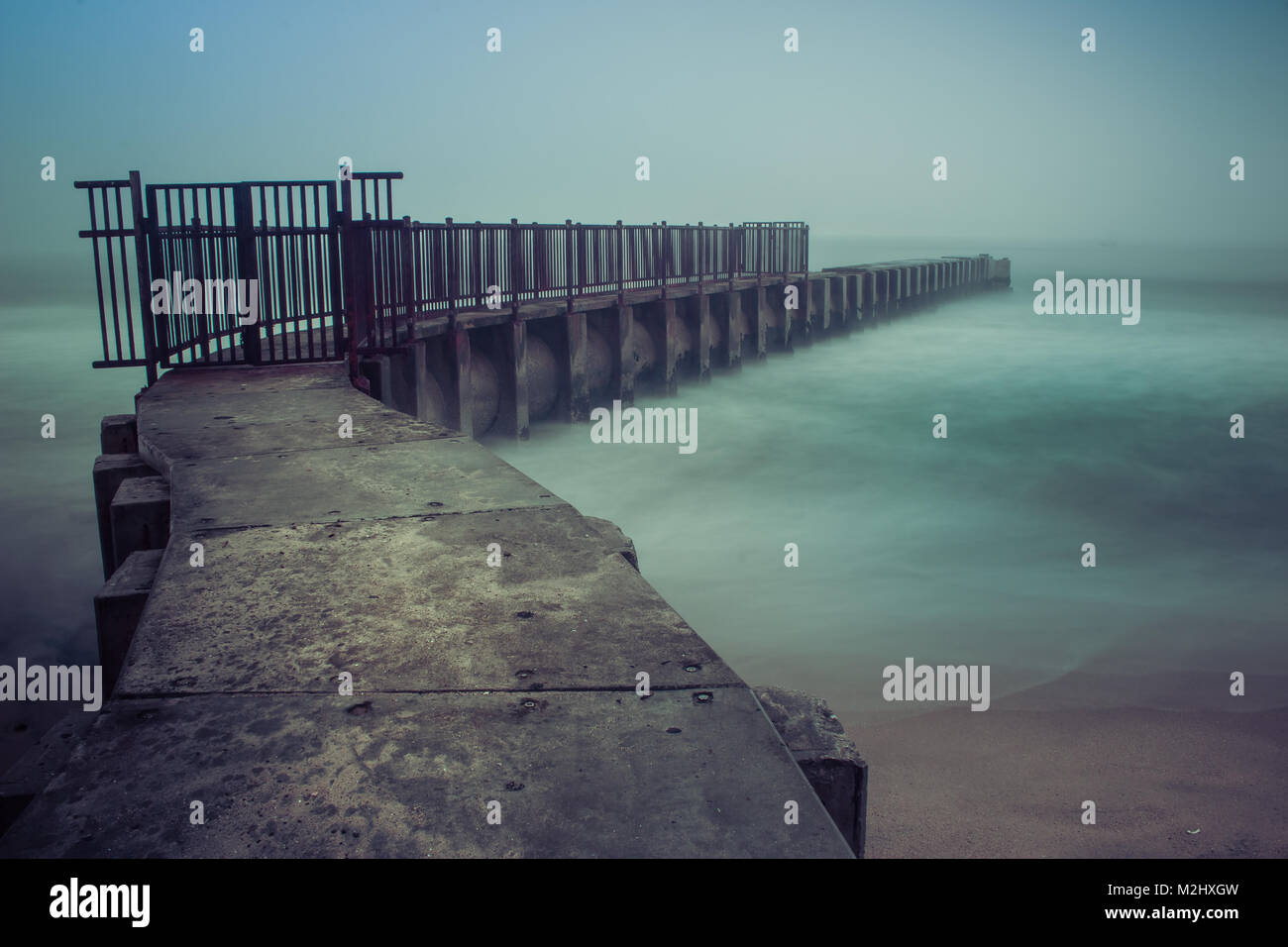 Long-exposure photo of waves crashing into McGurk Beach Jetty on a ...