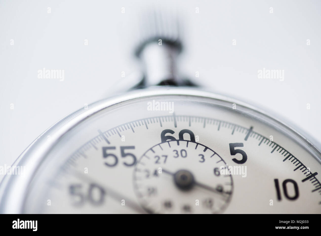 Close-up photograph of silver stopwatch. High key lighting on white ...