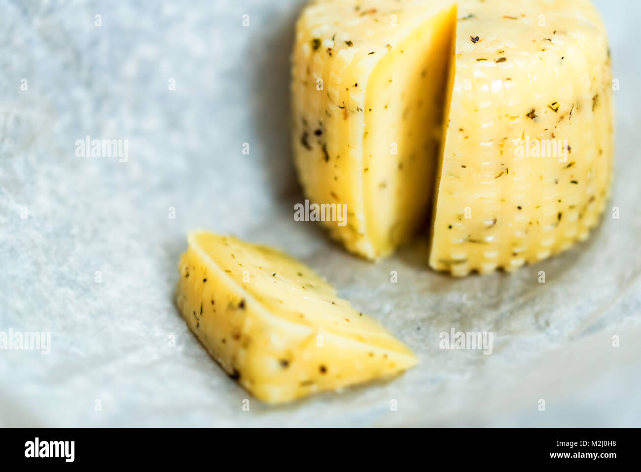 Rustic cheese with herbs on paper background Stock Photo - Alamy