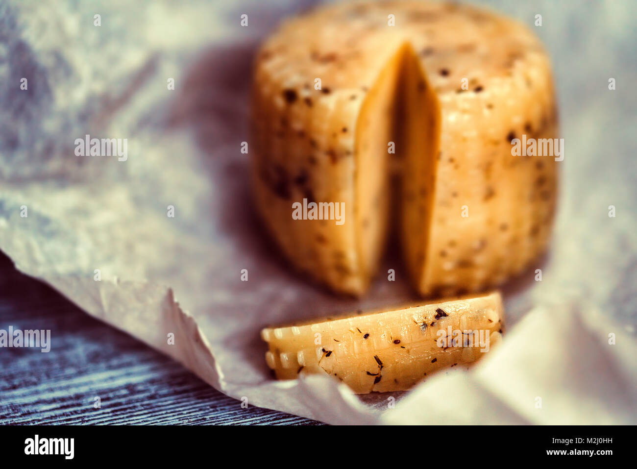 Rustic cheese with herbs on paper background Stock Photo - Alamy