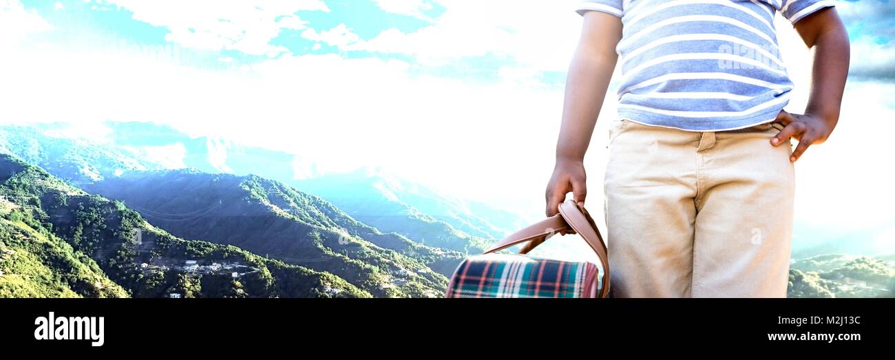 Travelling boy with bag in front of mountain landscape Stock Photo - Alamy