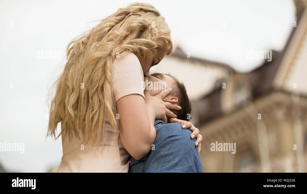 Boyfriend raising his girlfriend up and kissing her, passionate ...