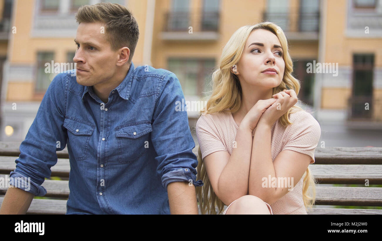 Couple breaking up, upset man and crying woman sitting on bench ...