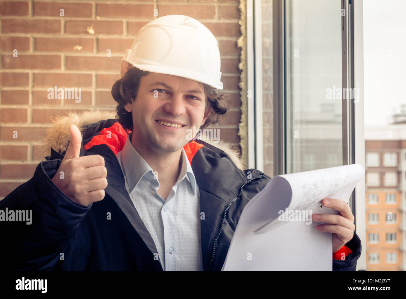 A handsome construction worker giving a thumbs-up sign. Authentic ...