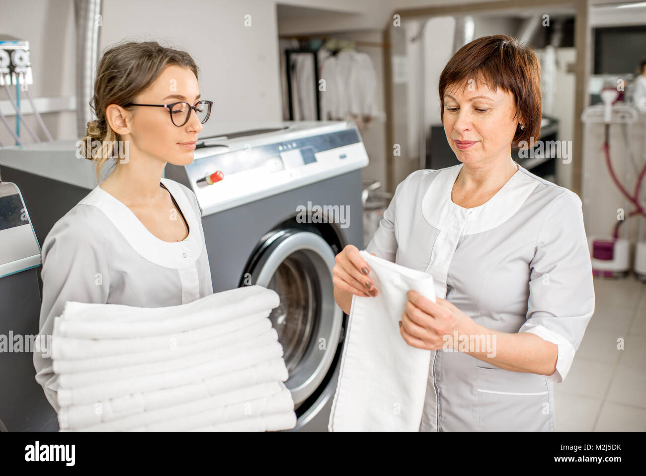 Senior washwoman with young assistant in the laundry Stock Photo - Alamy