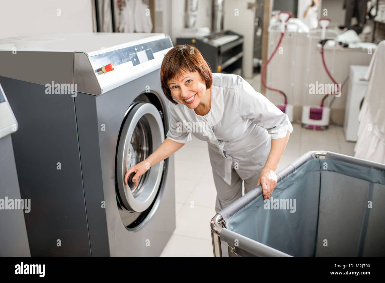 Senior woman loading washing machine hi-res stock photography and ...