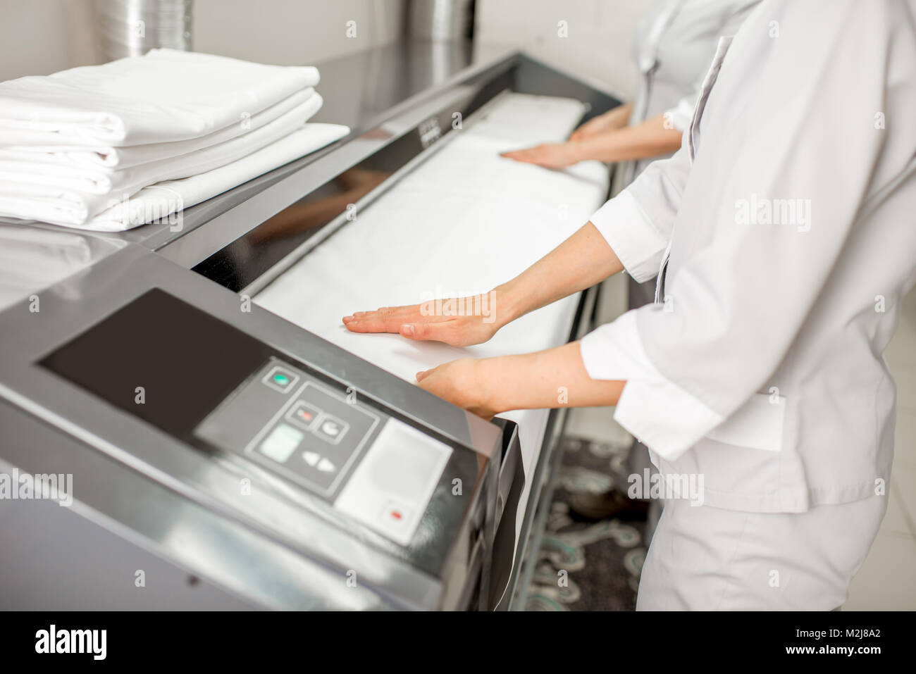 Working with professional ironing machine Stock Photo - Alamy