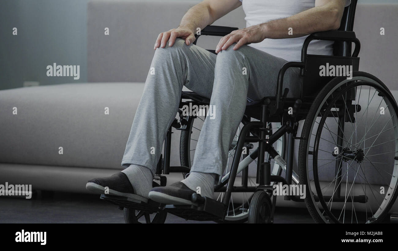 Sad man with disabilities sitting in wheelchair alone, suffering ...