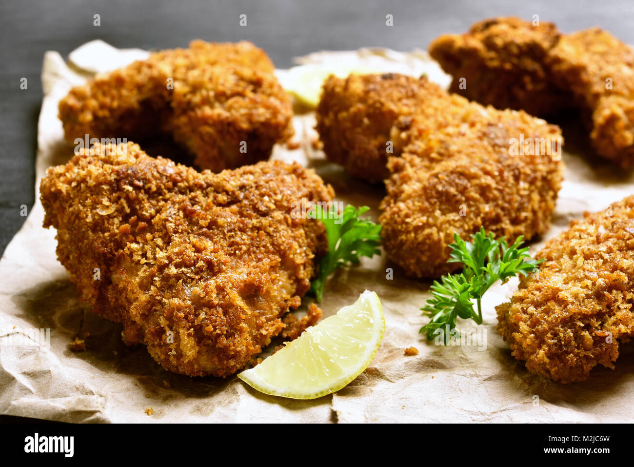 Close up of crispy breaded chicken wings on paper Stock Photo - Alamy