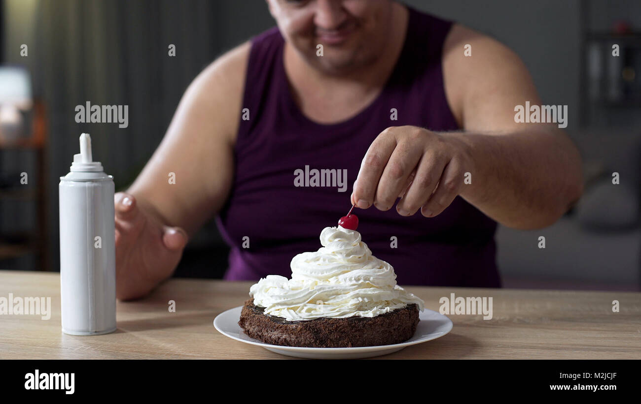 Happy fat man eating chocolate hi-res stock photography and images - Alamy