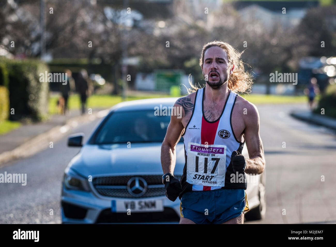 A runner competing in a road race in Newquay Cornwall Stock Photo - Alamy