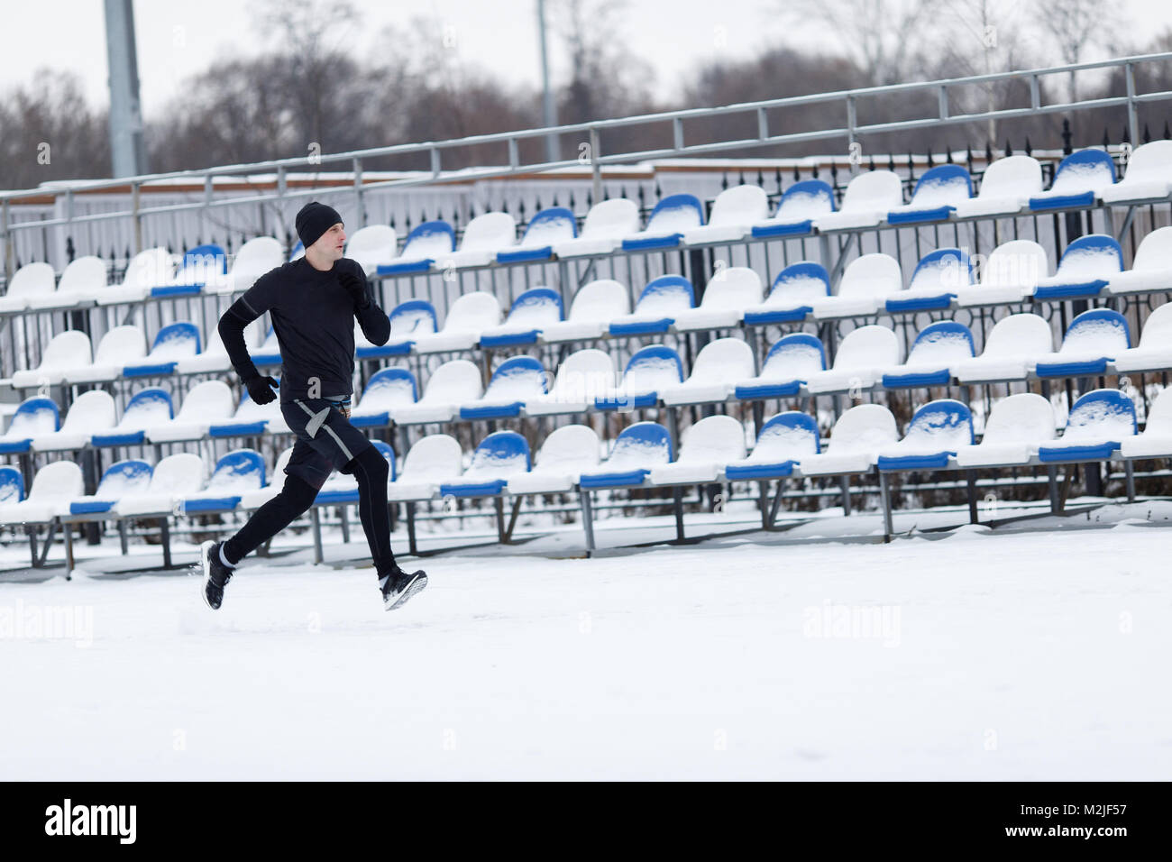 Picture of running man in sports clothes on stadium Stock Photo - Alamy