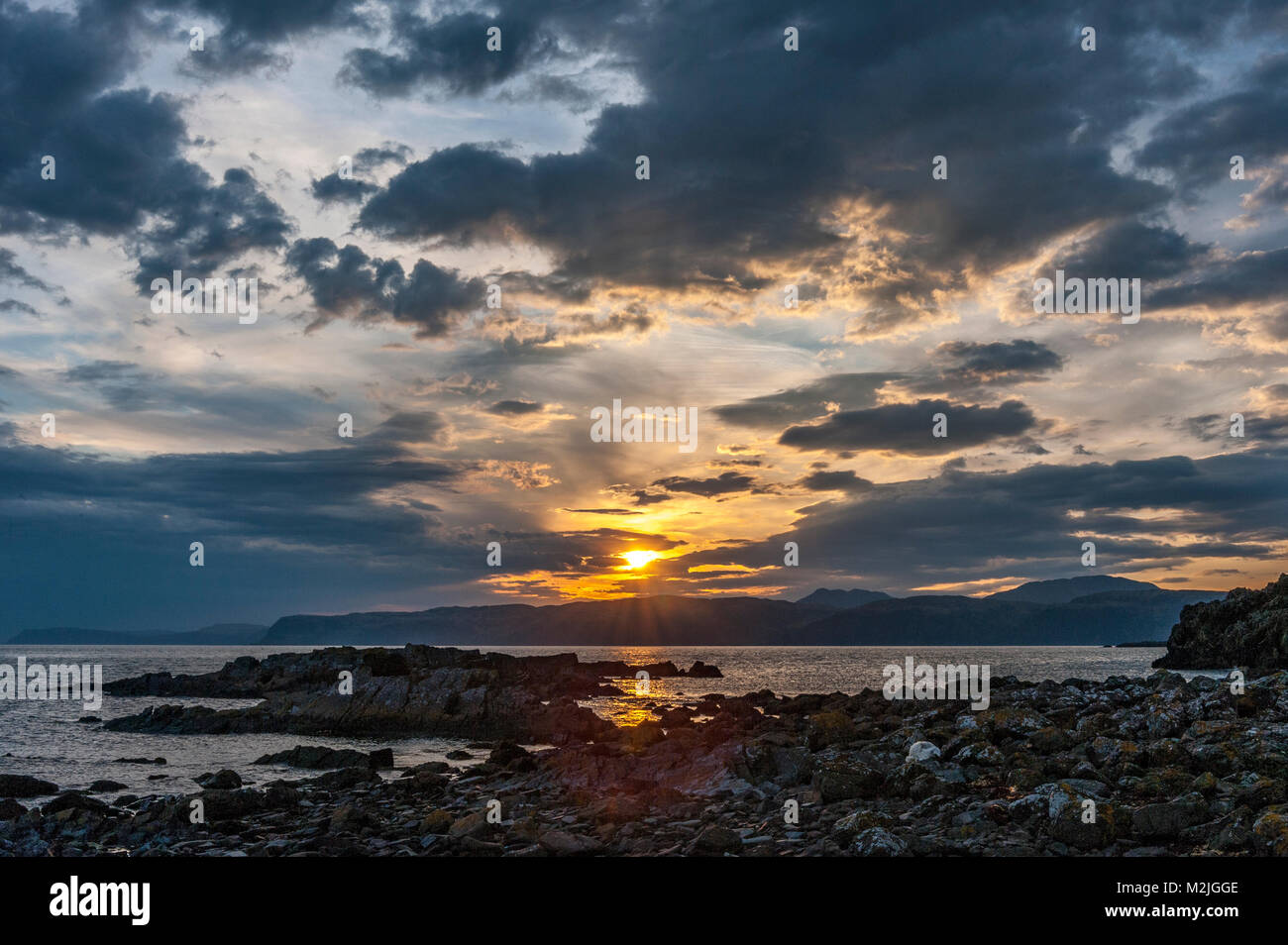 The sunset over Isle of Mull from Seil Island Stock Photo - Alamy