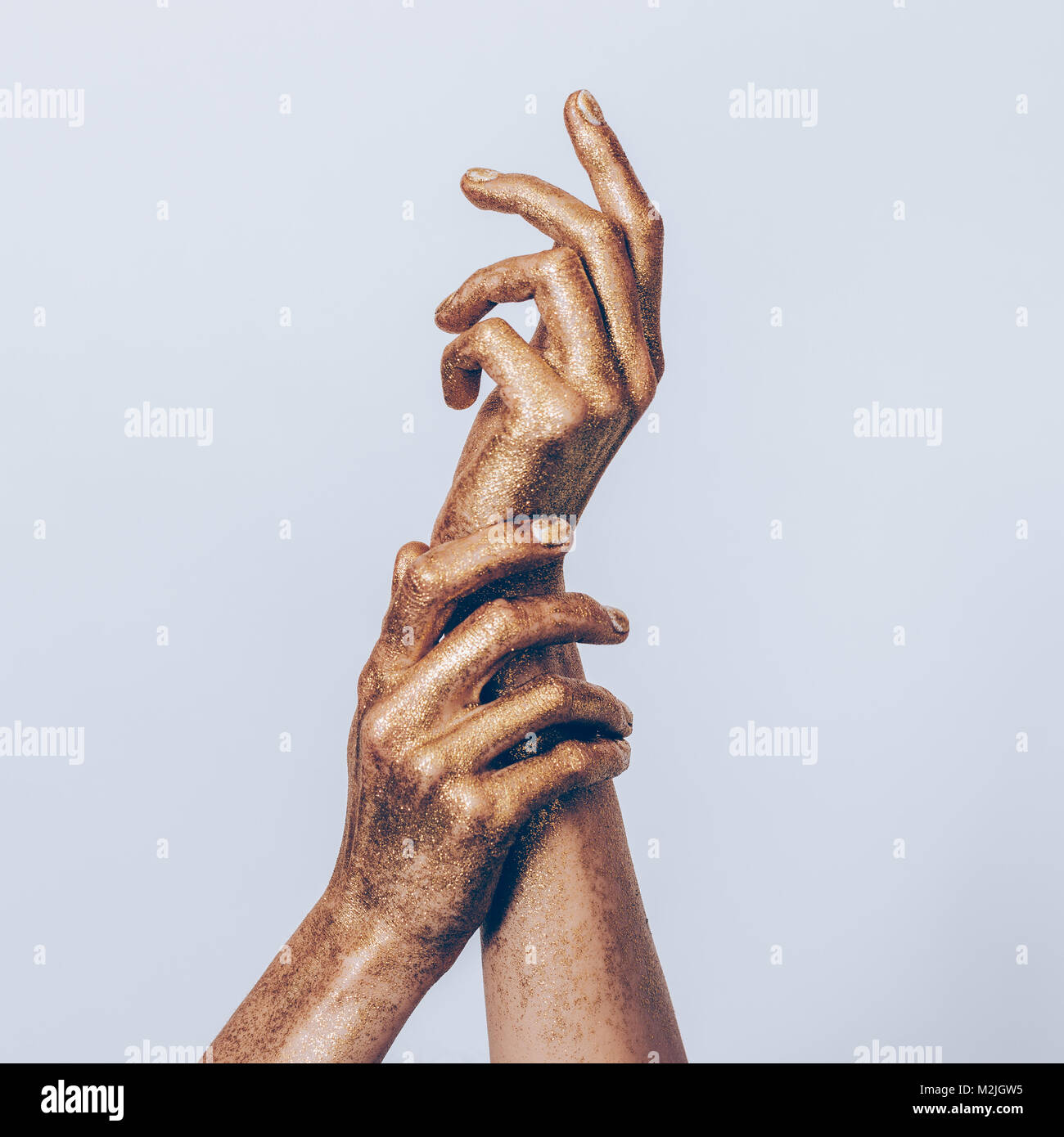 Golden female hands posing against a gray background close-up Stock ...